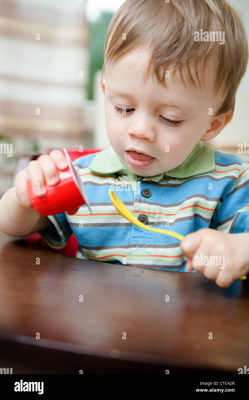 little child eating a yougurt Stock Photo - Alamy