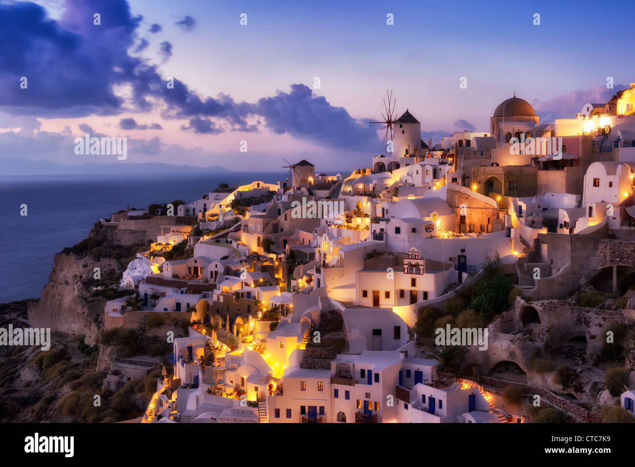 Oia, village in Santorini, Greece with glow of city lights as dusk ...