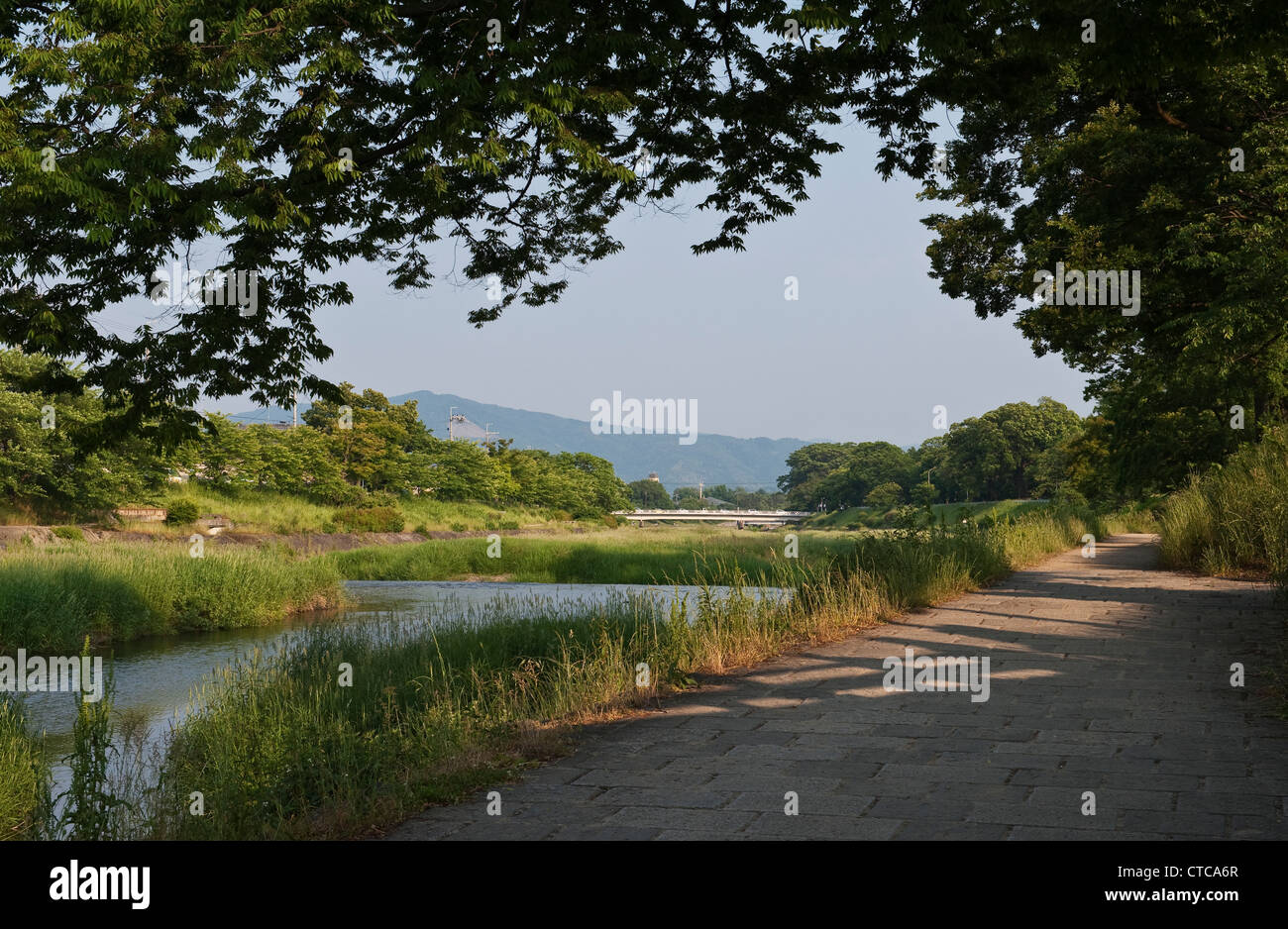The quiet path along the banks of the Kamo River in Kyoto, Japan, a ...