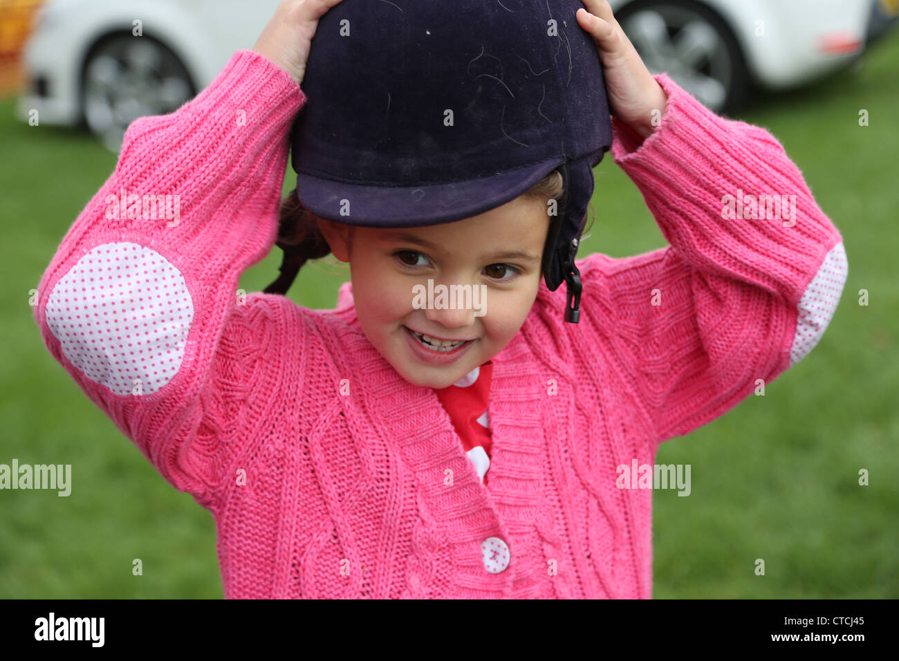 Girl Putting On Horse Riding Helmet At Cheam Village Fair Surrey ...