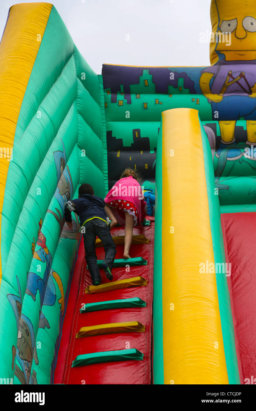 Children Climbing Up The Simpsons Inflatable Slide Cheam Village Fair ...