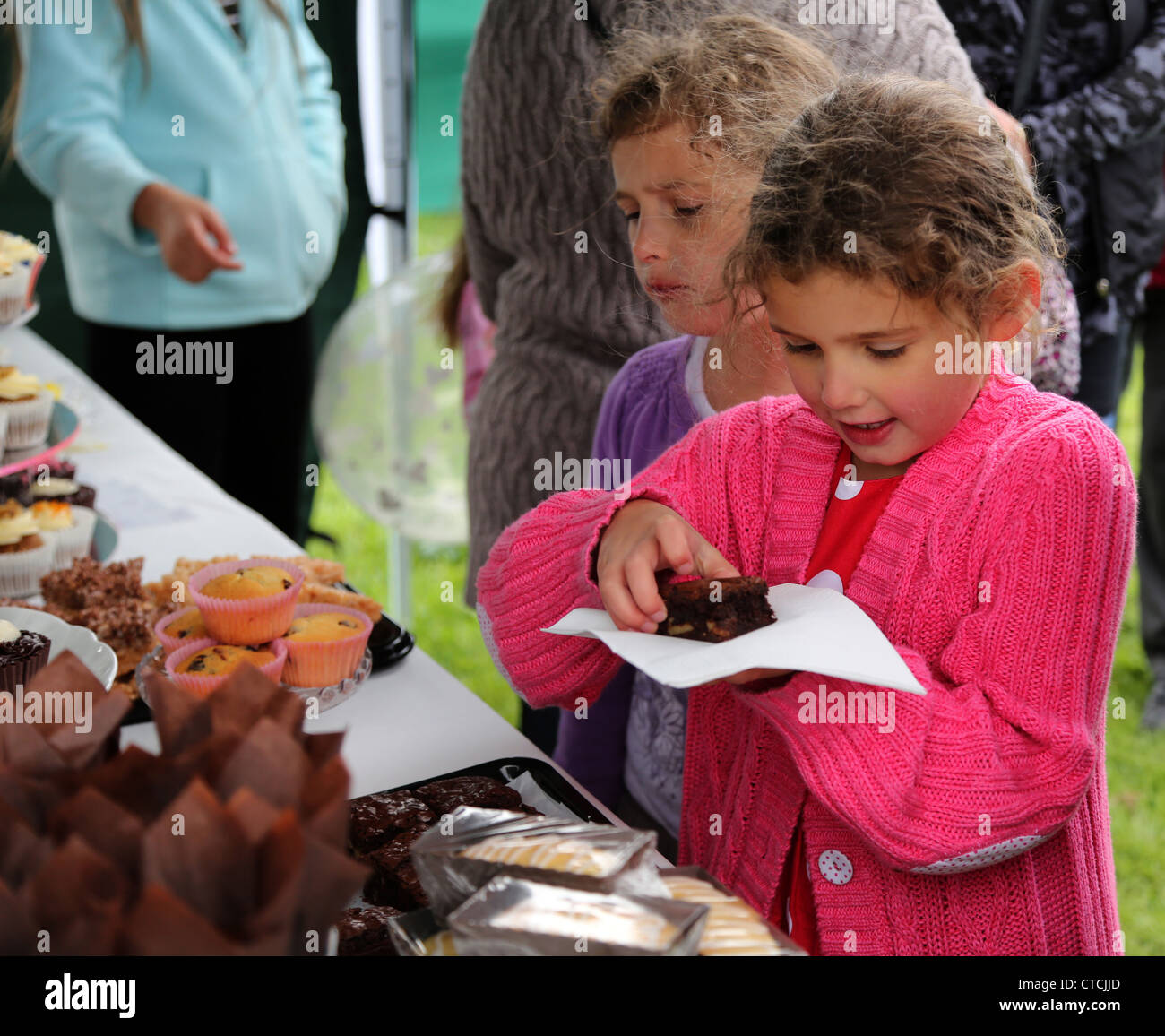 Girl Choosing a Piece of Cake Off Of Cake Stall At Cheam Village Fair ...