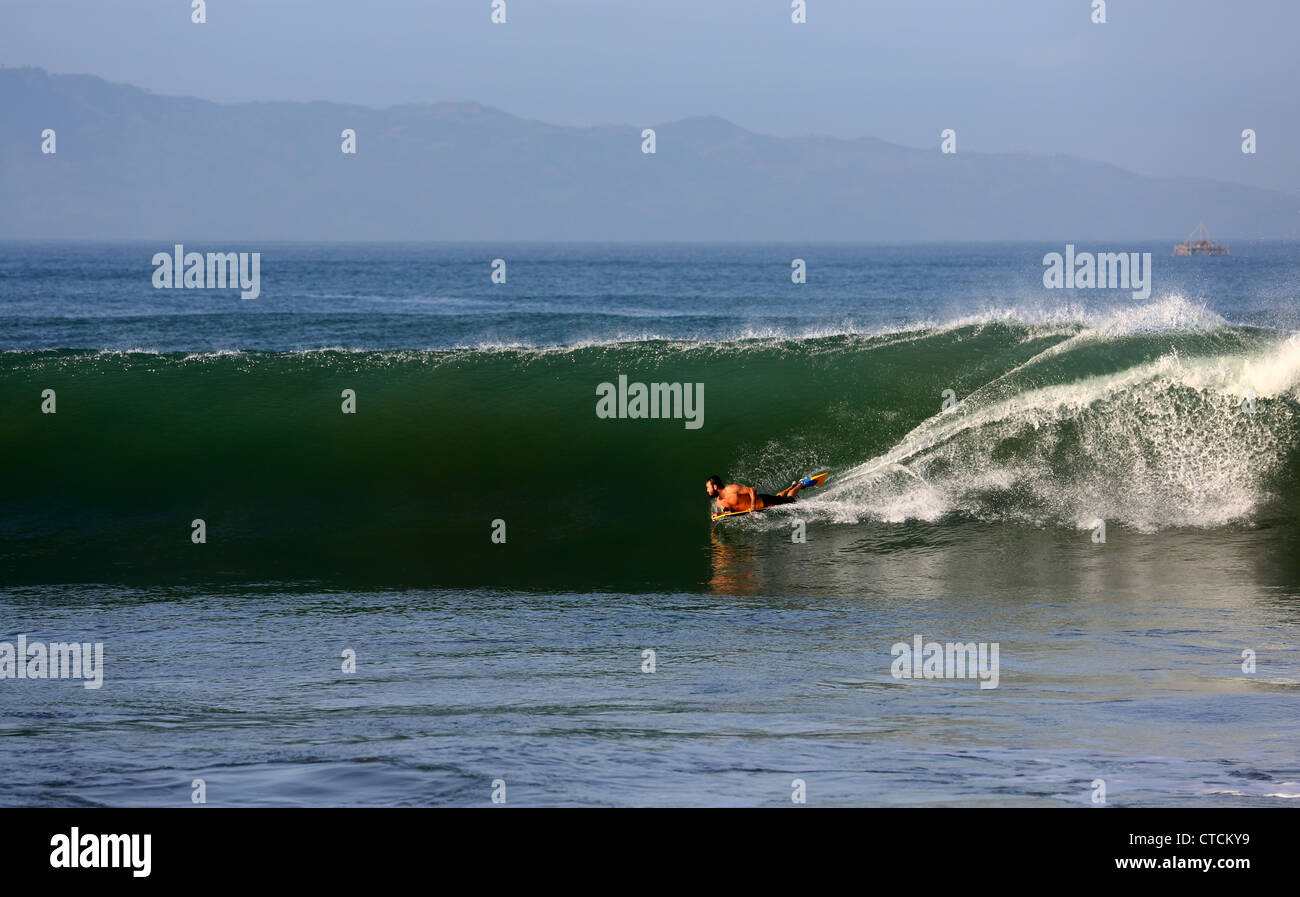 Man body surfing a large wave in West Java, Indonesia Stock Photo - Alamy
