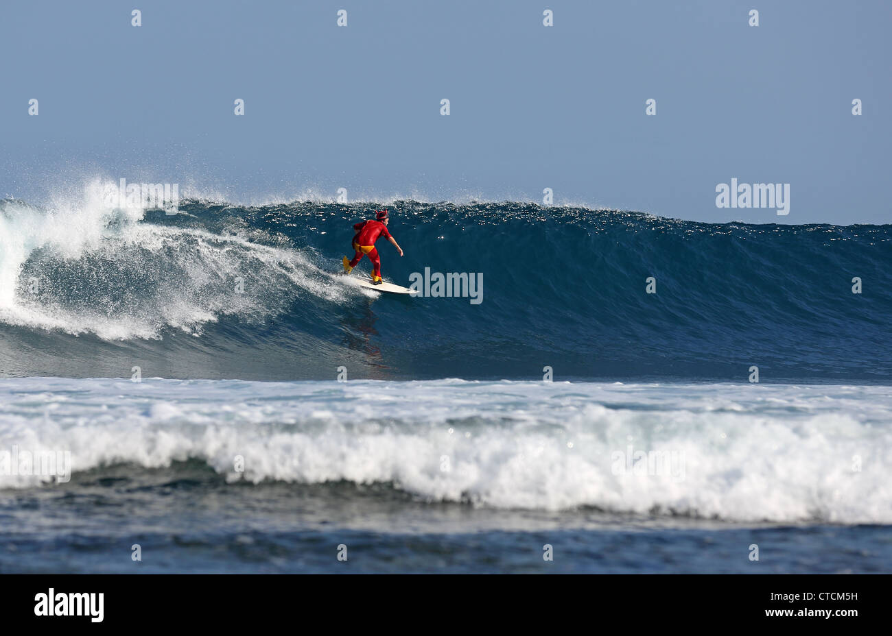 Bearded man surfing a wave wearing red superhero costume Stock Photo ...