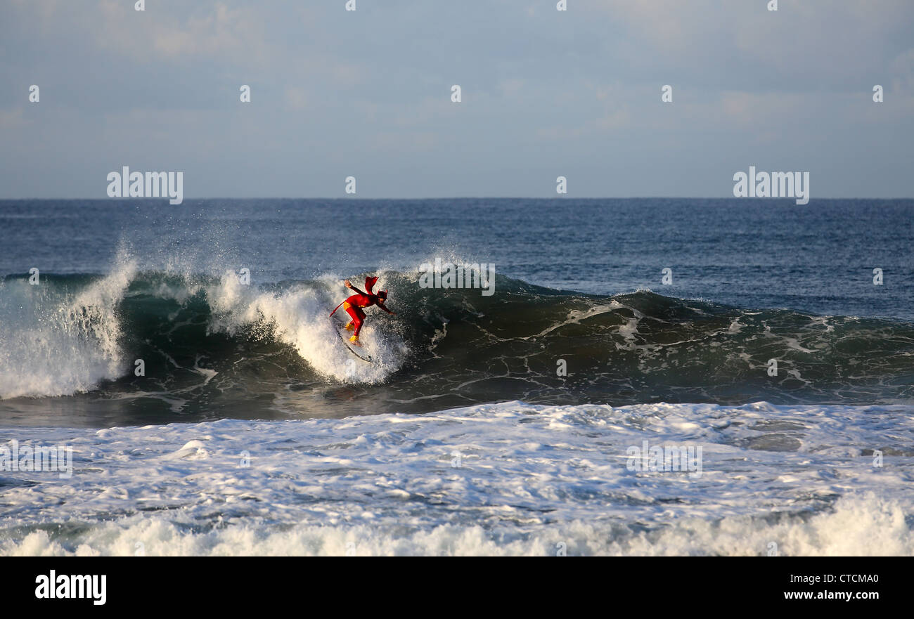 Bearded man surfing a wave wearing red superhero costume Stock Photo ...