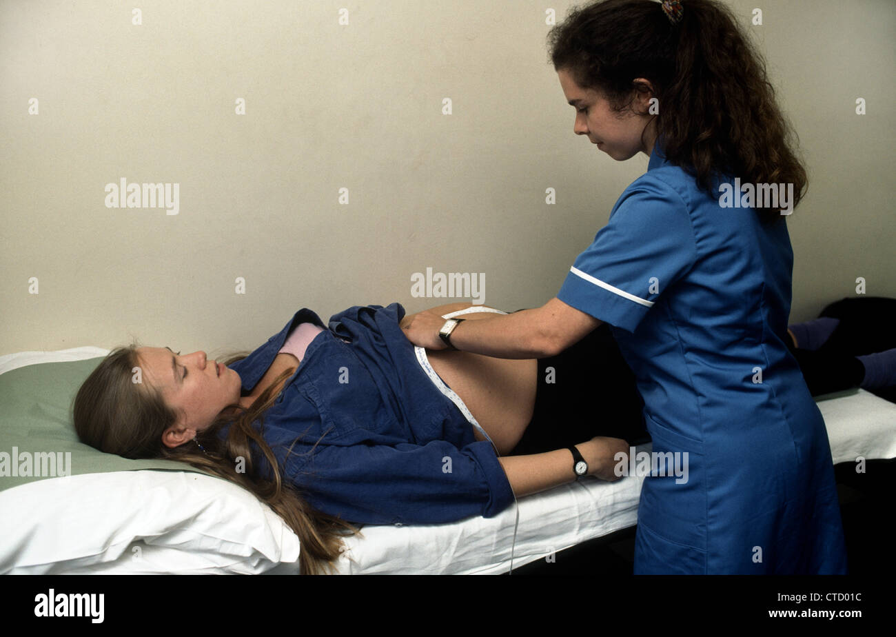 pregnant woman having examination by a midwife Stock Photo - Alamy