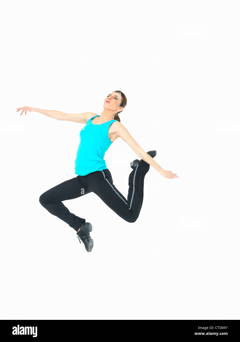 young woman in fitness outfit showing jumping moves on white background ...
