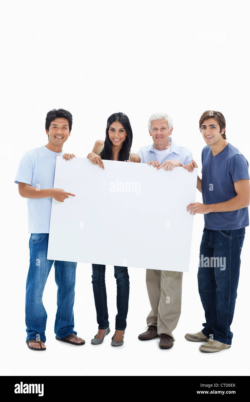 Smiling people holding and showing a big sign Stock Photo - Alamy
