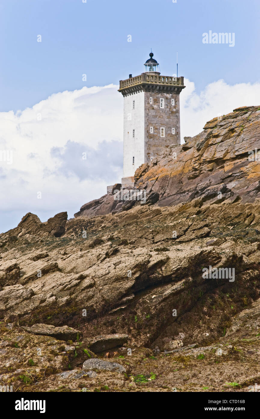 Lighthouse by the coast in Britain with clouds and stone beach Stock ...