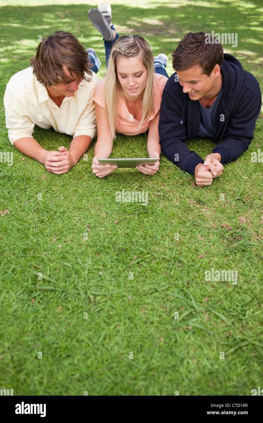 Three young people using a tactile tablet Stock Photo - Alamy