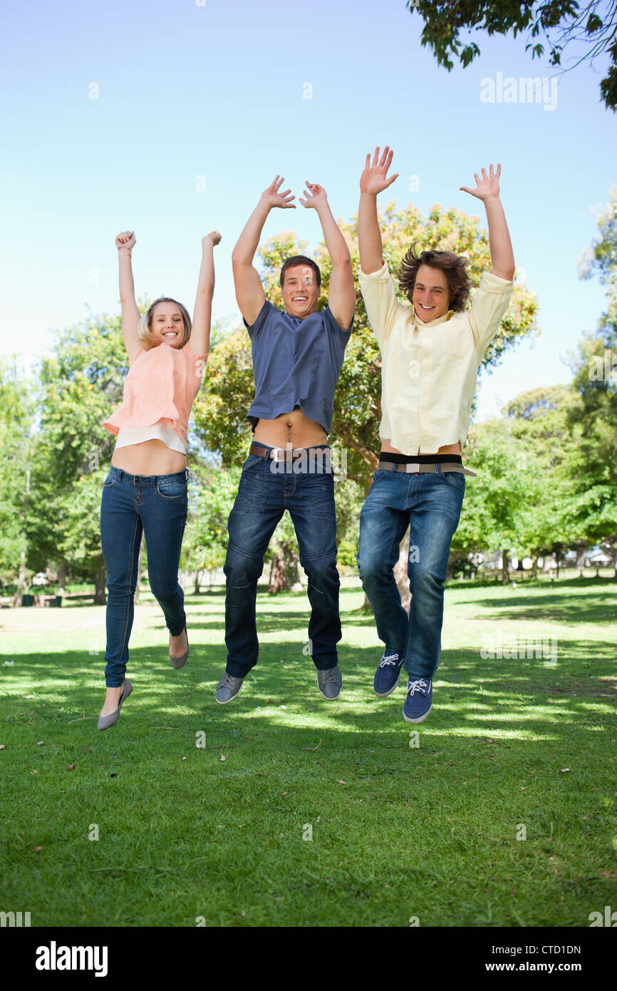 Three students jumping Stock Photo - Alamy