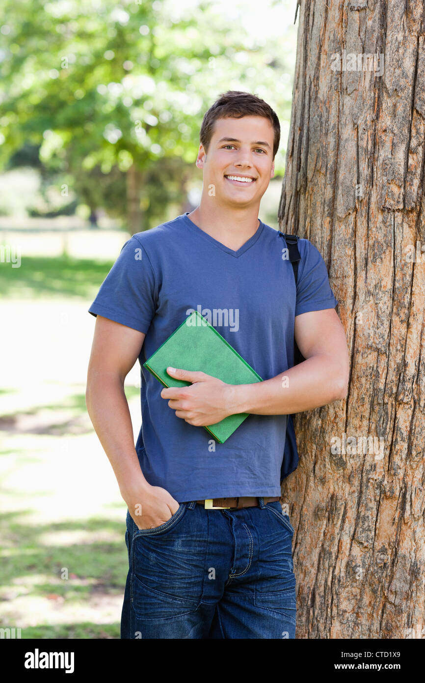 Portrait of a muscled student holding a textbook Stock Photo - Alamy
