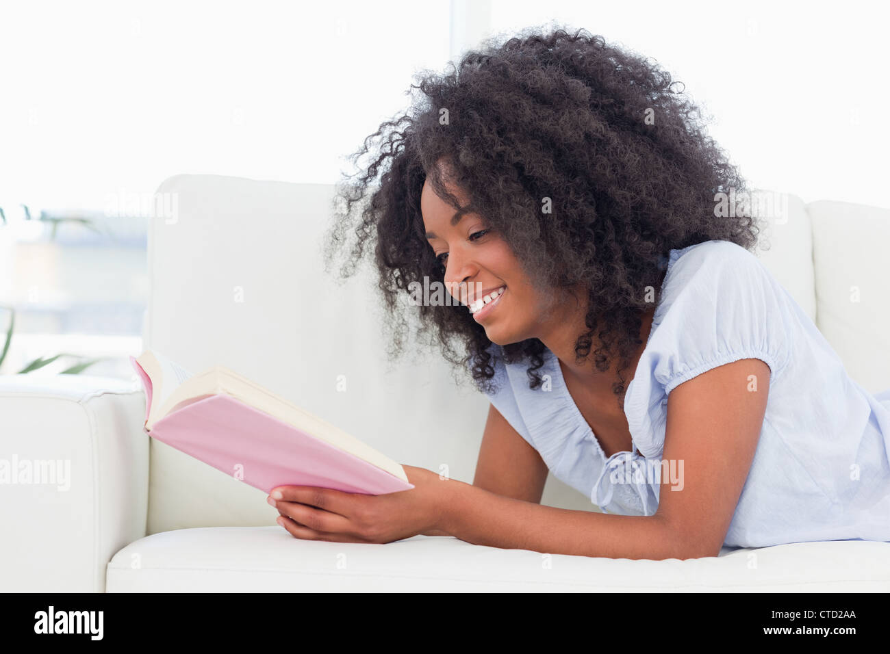 Happy woman reading a book Stock Photo - Alamy