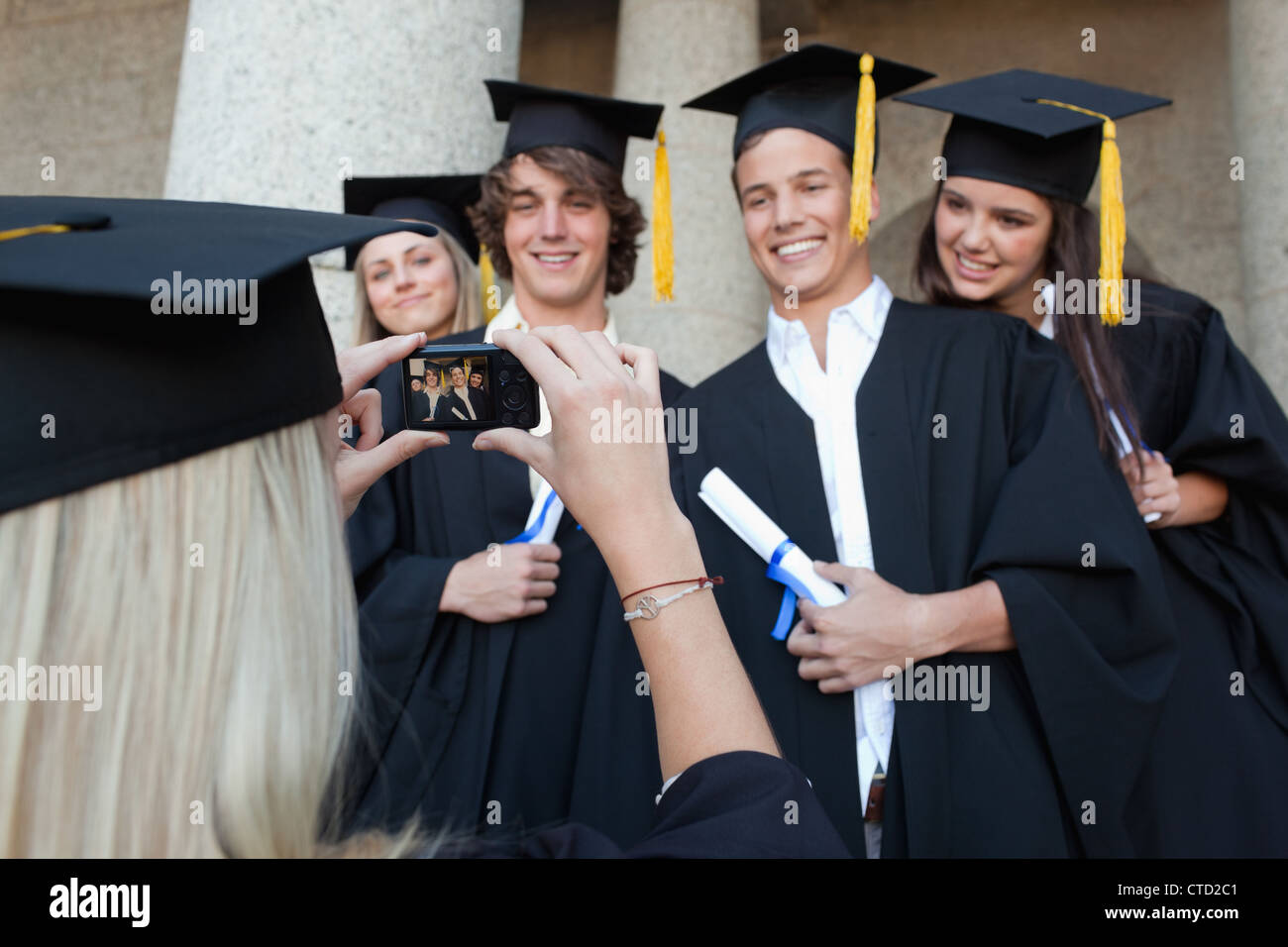 Close-up of a female graduate taking a picture of her friend Stock ...