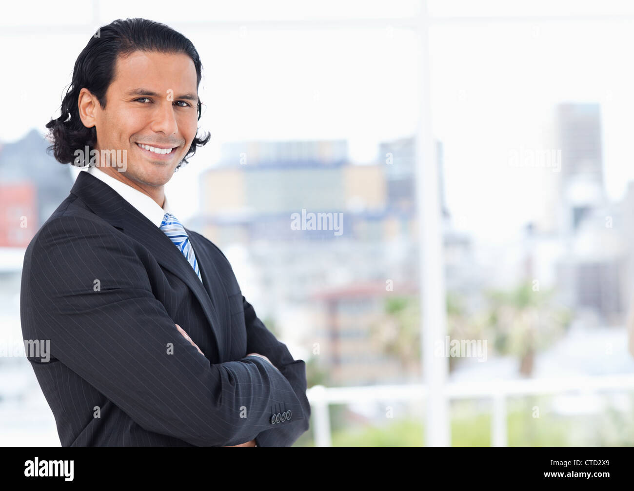 Executive standing upright in front of a window and looking towards the ...