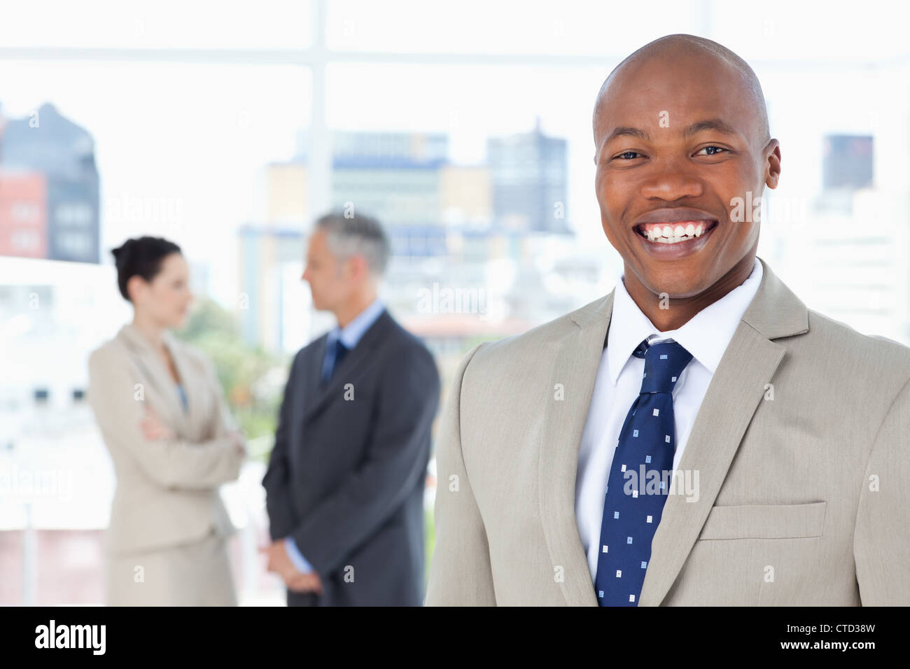 Young manager standing upright while smiling Stock Photo - Alamy