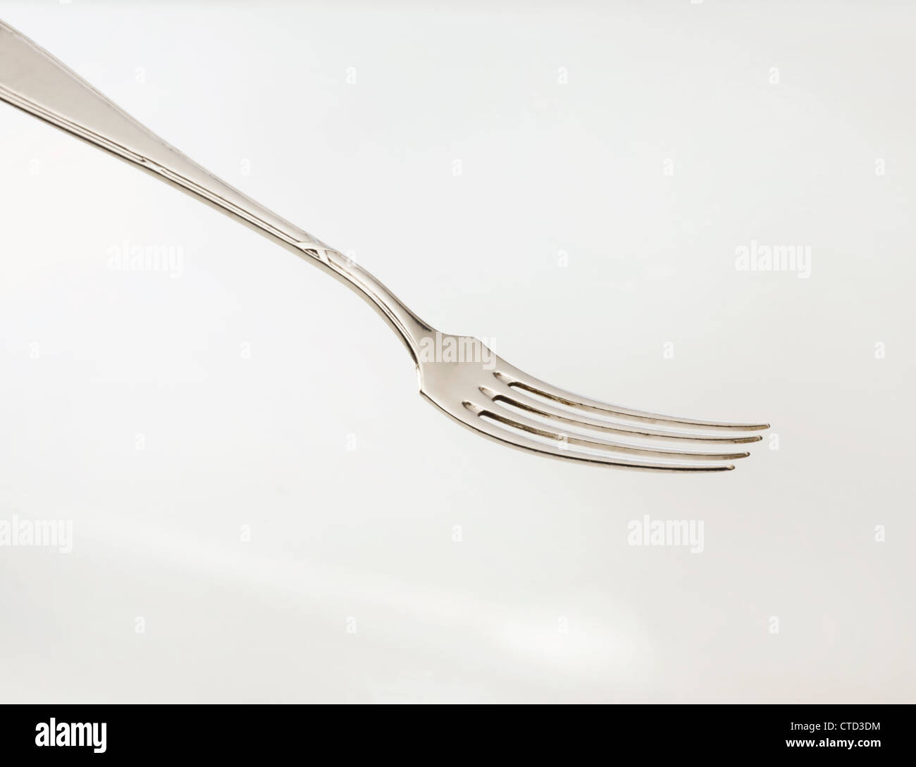 Silver fork in front of a light background Stock Photo - Alamy
