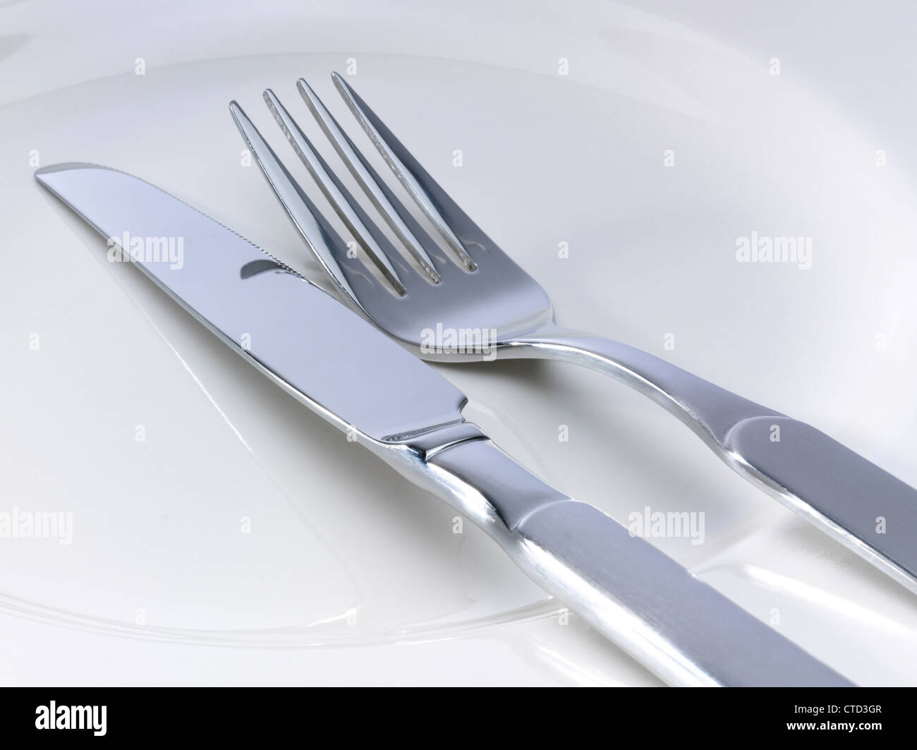 Silverware on a ceramic plate Stock Photo - Alamy