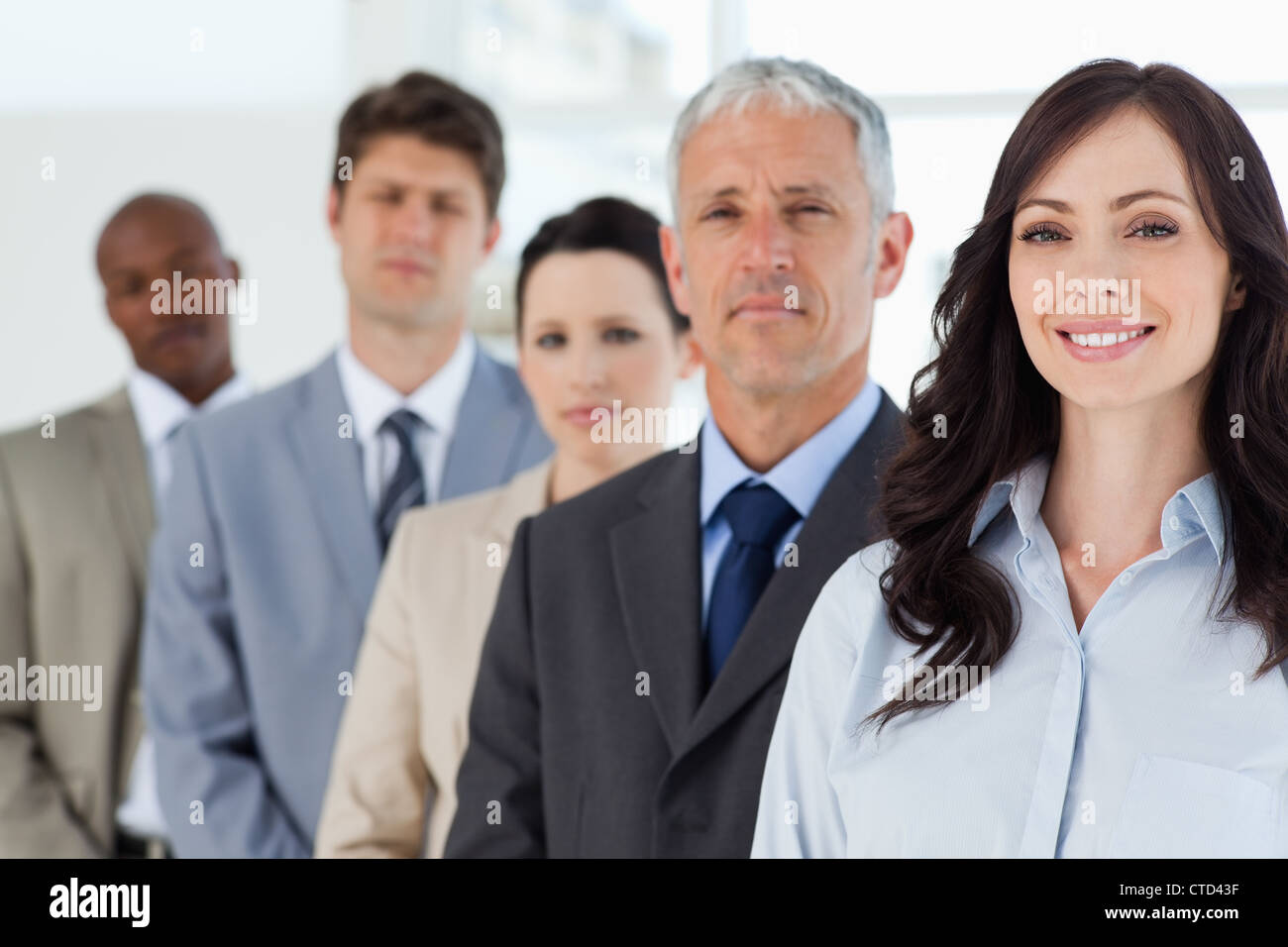 Young smiling executive followed by her full business team Stock Photo ...