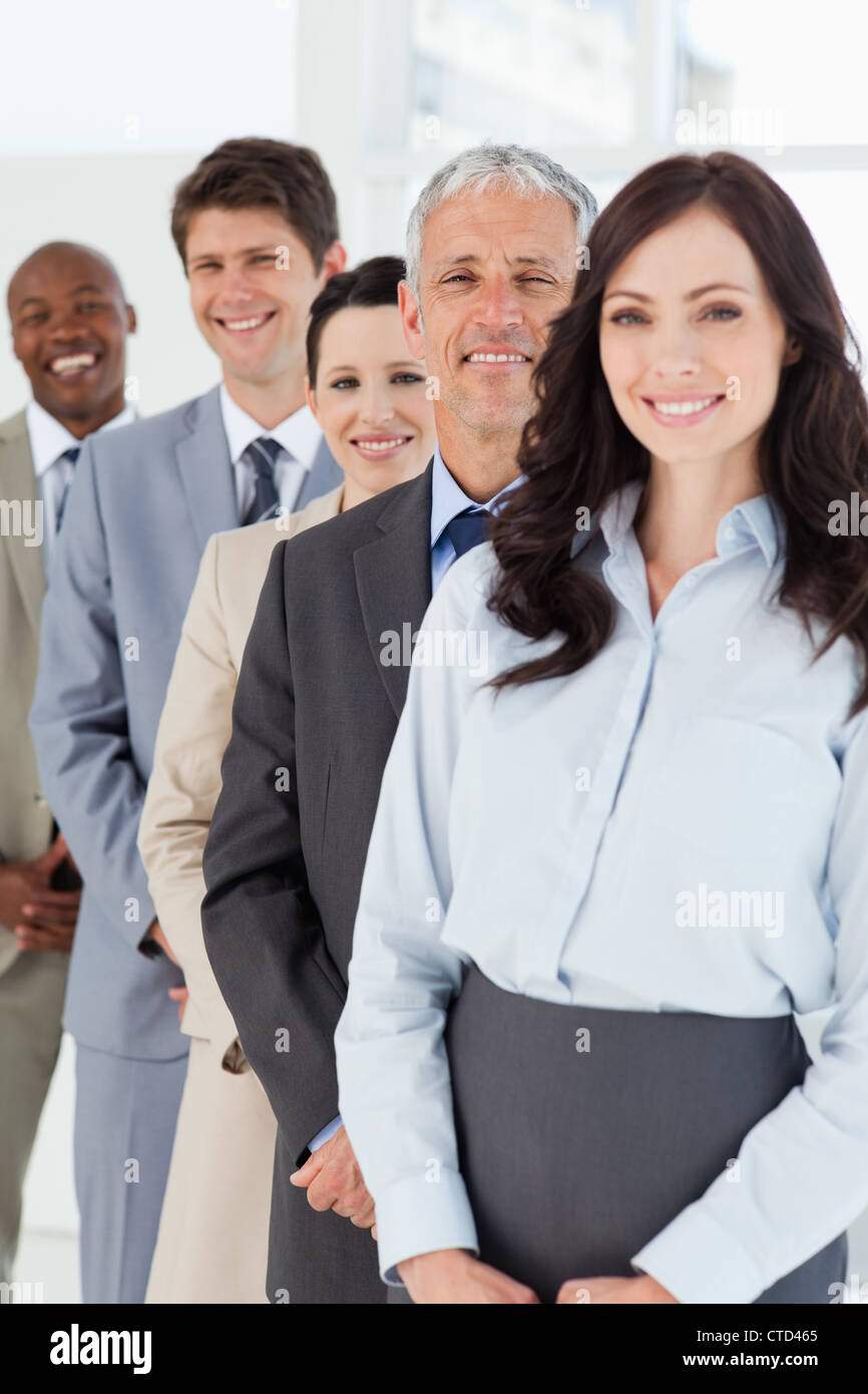 Confident and smiling manager standing among his employees Stock Photo ...
