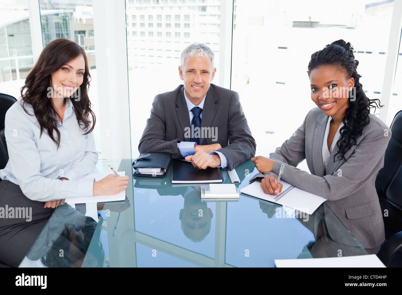 Smiling director sitting at the desk in front of the window between two ...