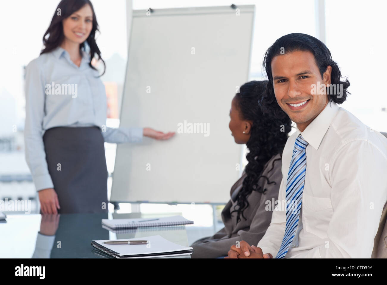 Smiling employee listening to the presentation given by a colleague ...