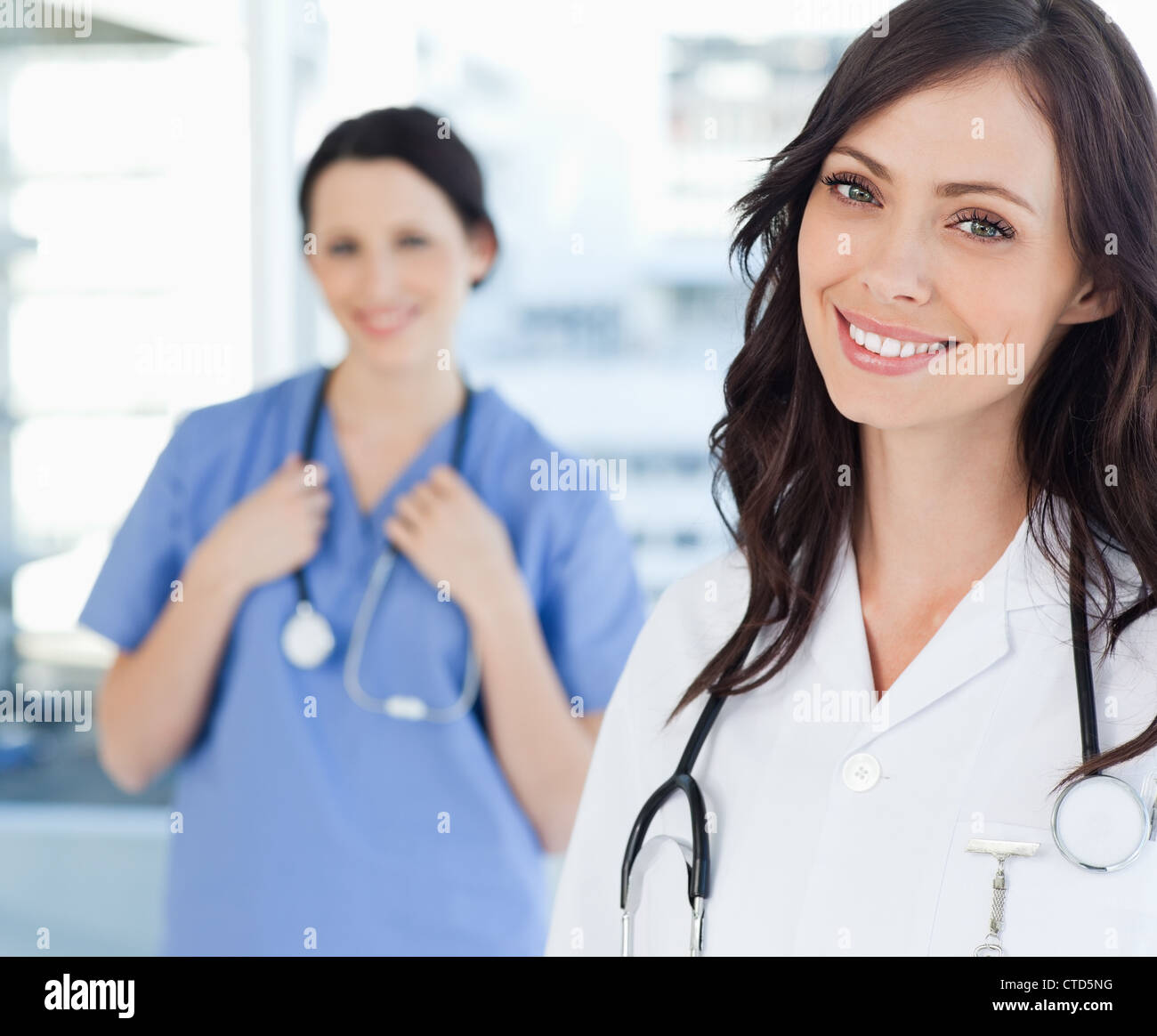 Smiling nurse standing upright while leaning her head to the side Stock ...
