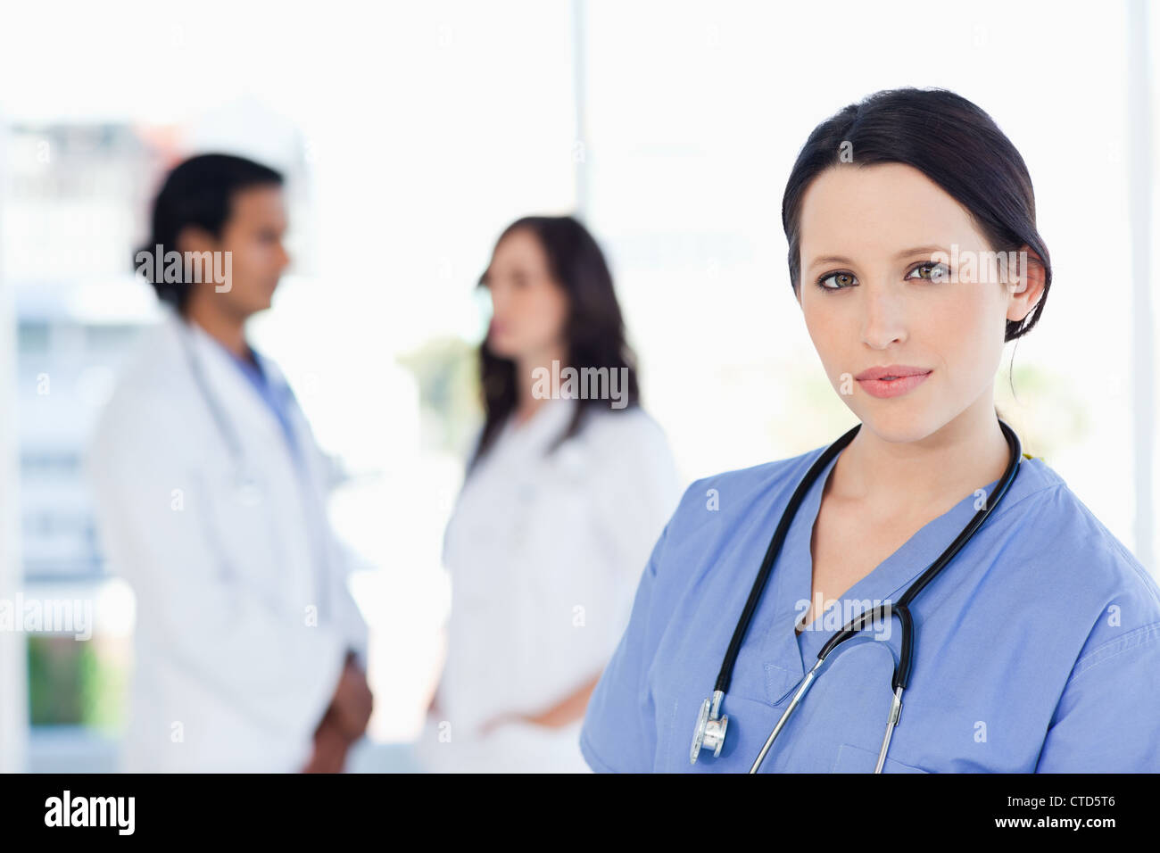 Calm nurse standing upright with her stethoscope around her neck Stock ...
