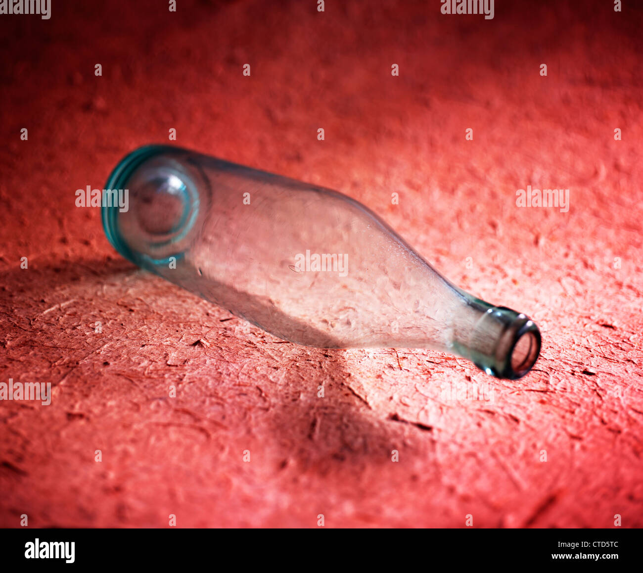 Empty bottle on a red surface Stock Photo - Alamy