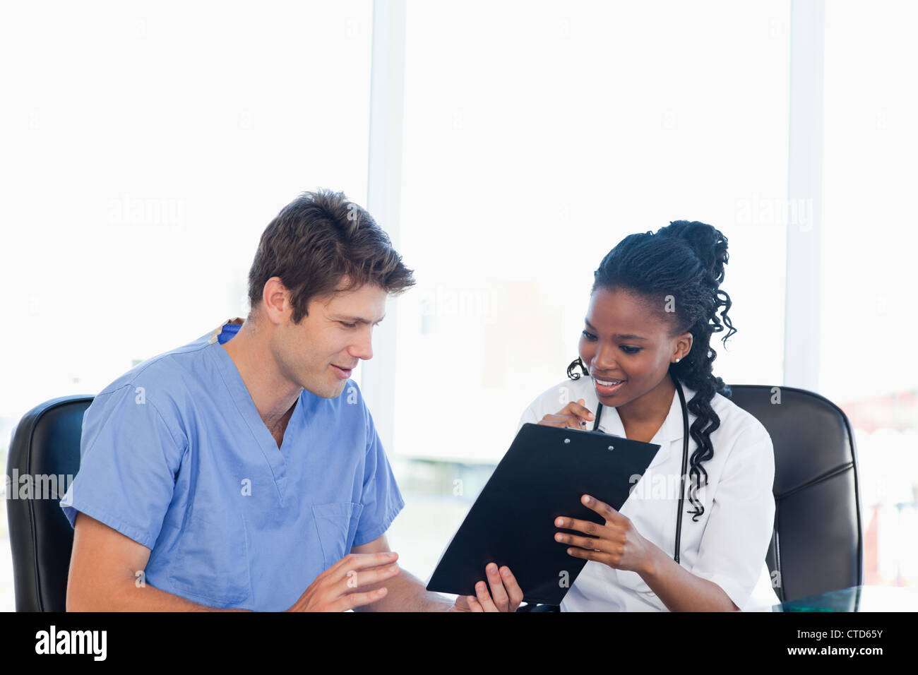 Two nurses working on a professional clipboard in a bright room Stock ...