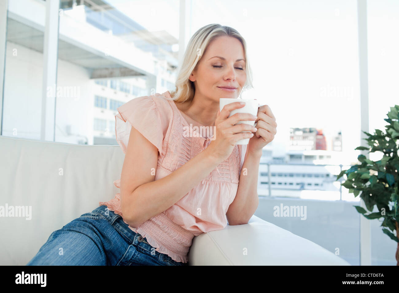 Blonde smelling her tea Stock Photo - Alamy