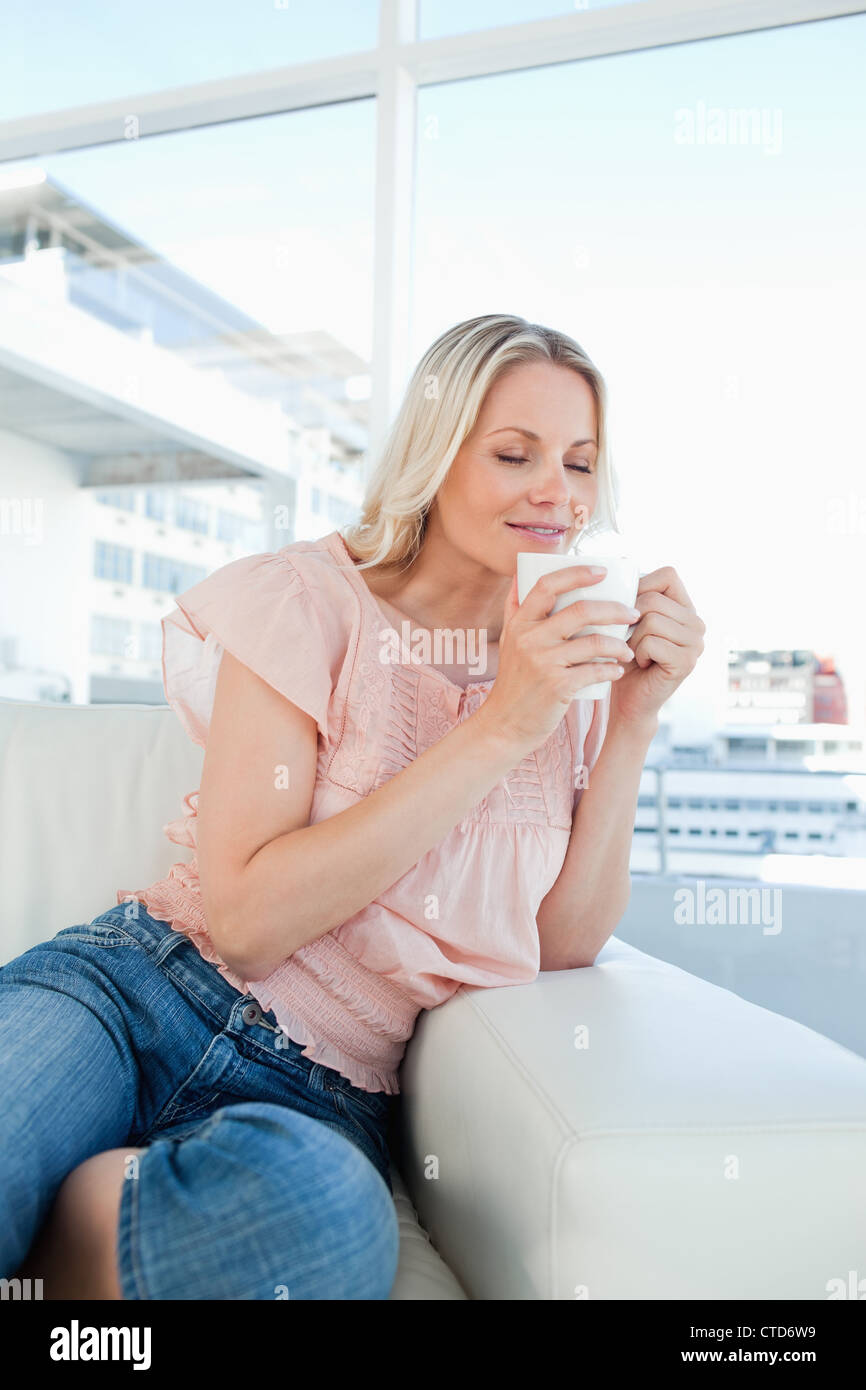 Blonde smelling her herbal tea Stock Photo - Alamy
