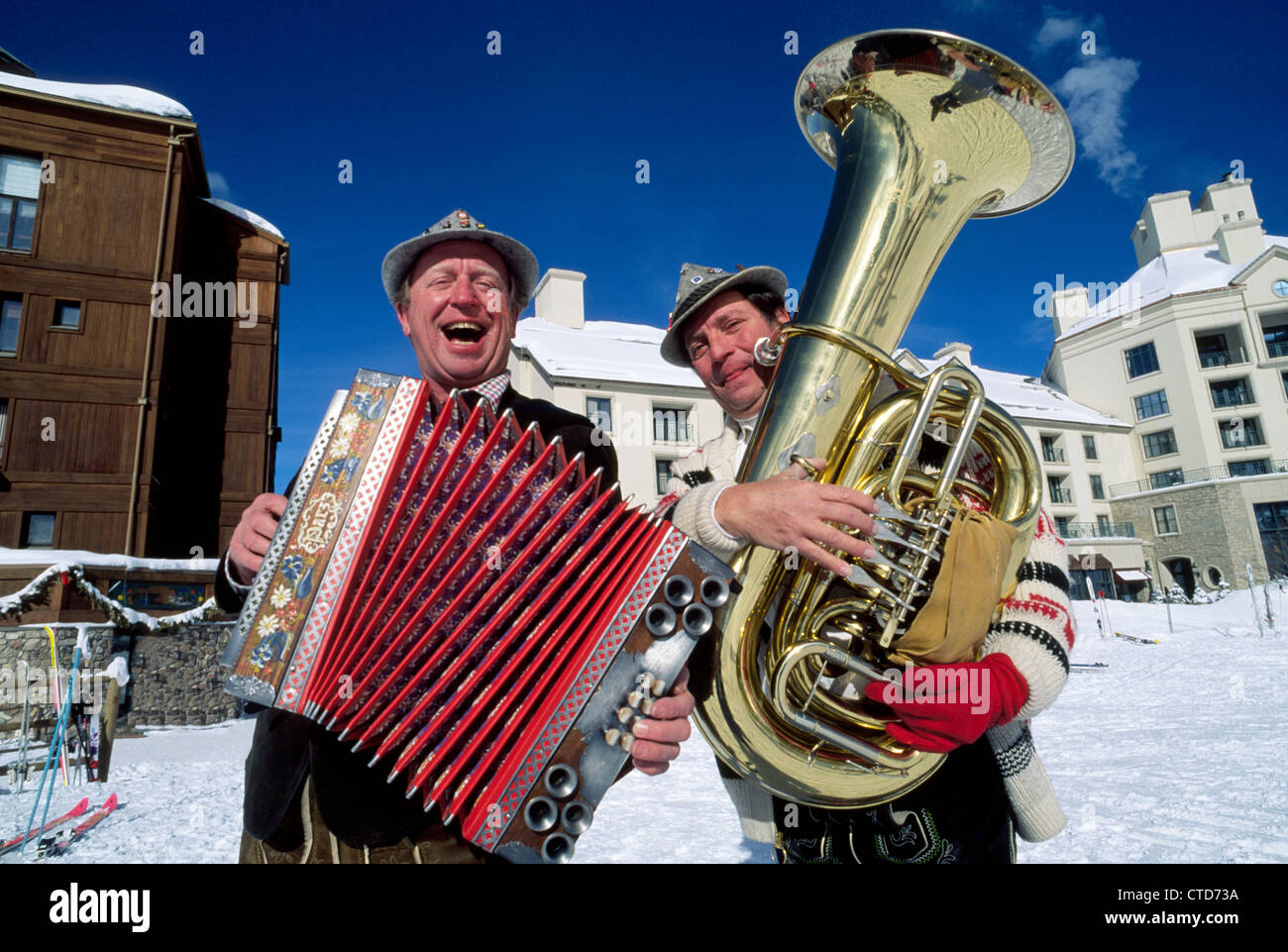 Two musicians with their keyboard and wind instruments wander outdoors ...