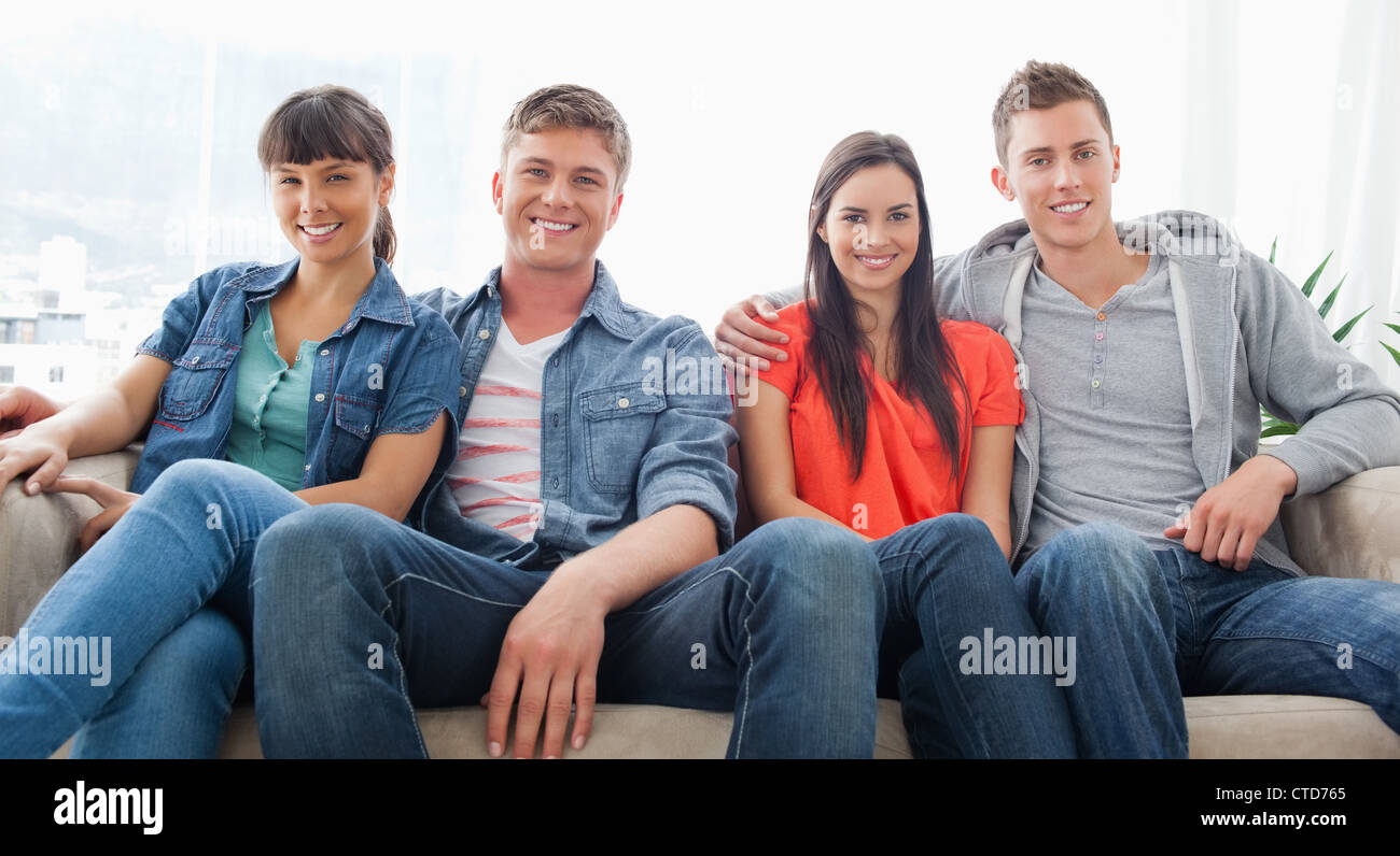 Two couples sit on the couch together looking into the couch Stock ...