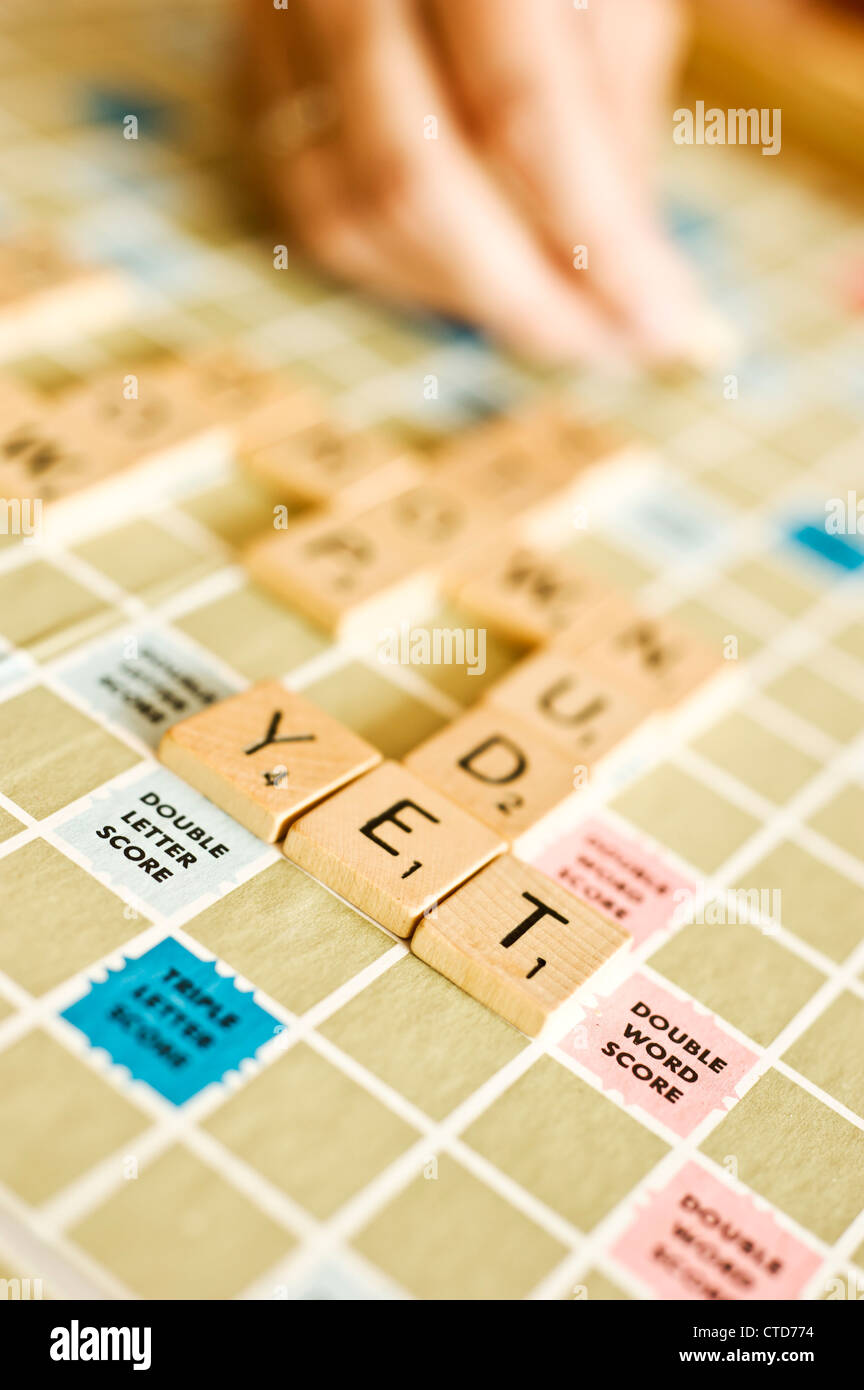 woman hand's playing a scrabble tile on the board Stock Photo - Alamy