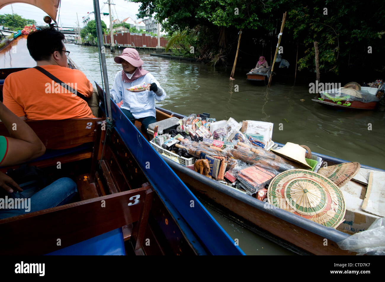 A boat vendor selling tourists drinks and souvenirs from his boat on ...