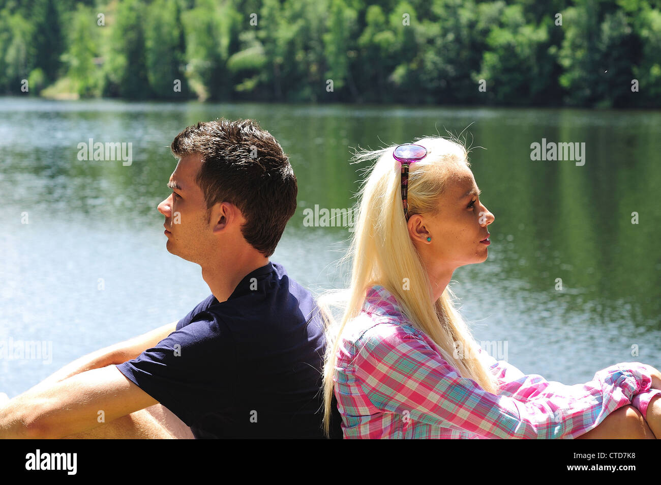 Young couple thinking at lake Stock Photo - Alamy