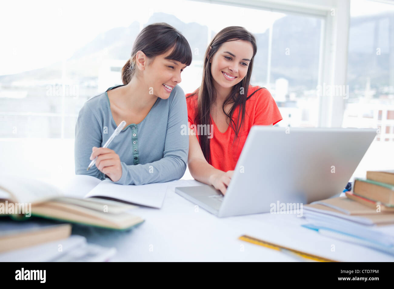 A couple of girls sitting together as they work on the laptop Stock ...