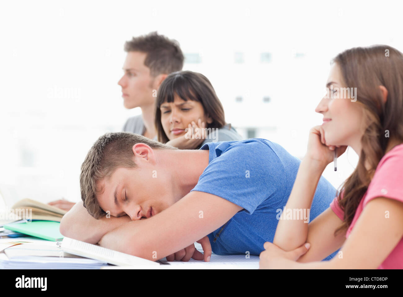 A sleeping student is being looked at by a confused fellow student ...