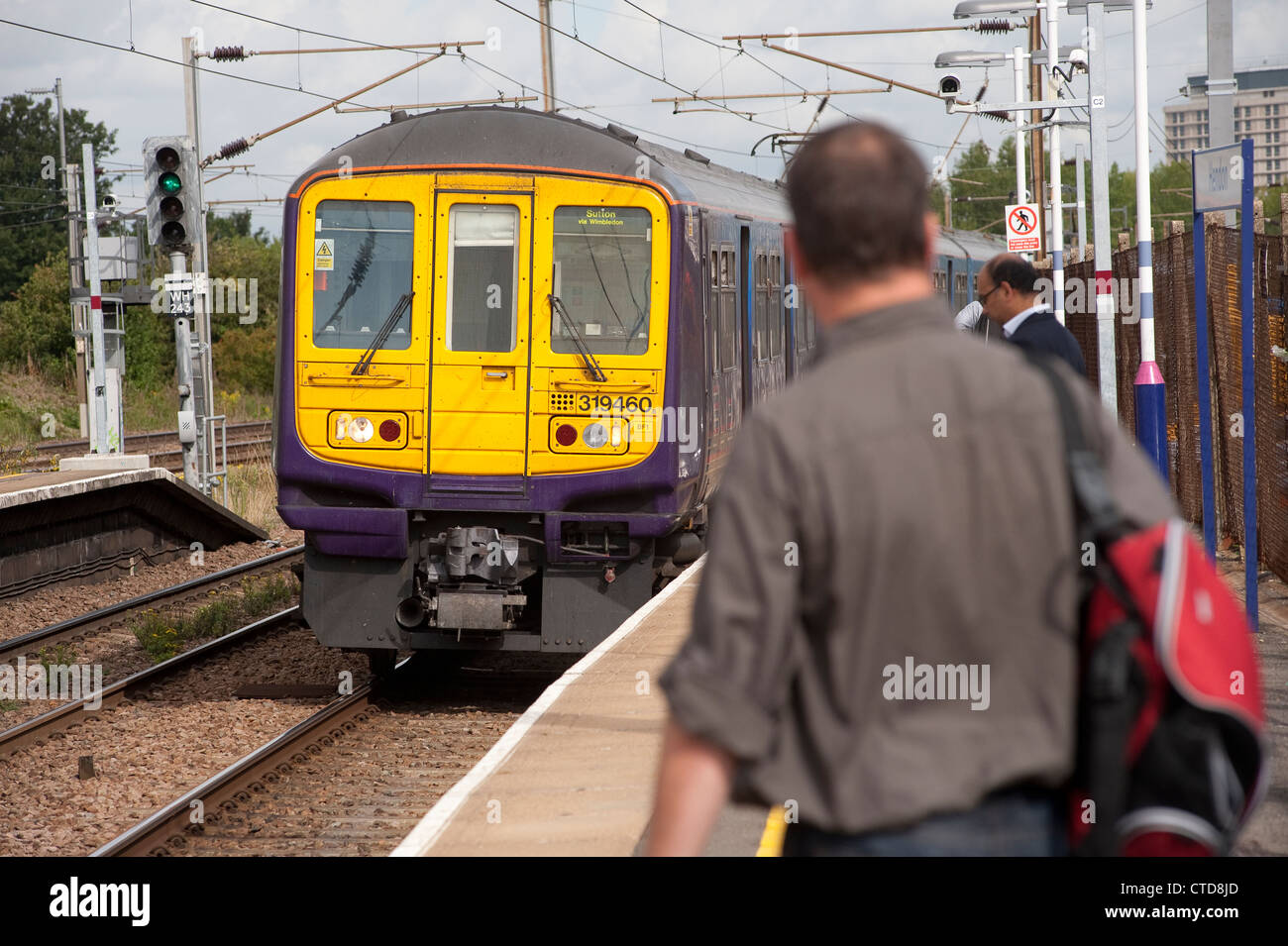 Passengers waiting on the platform as a train in First Capital Connect ...