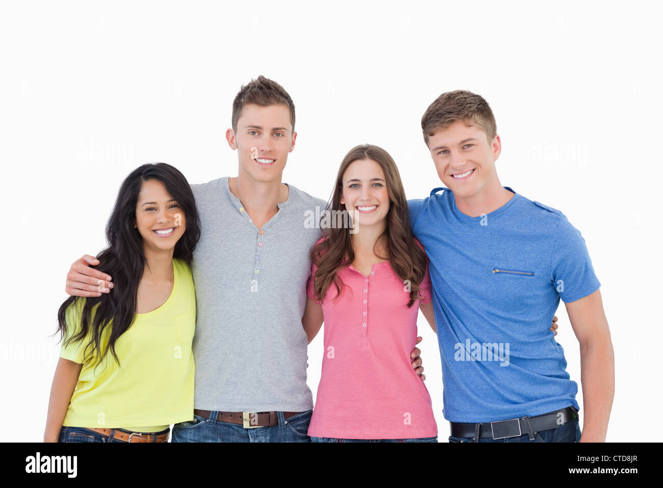 Four friends smiling and embracing each other as they look into the ...