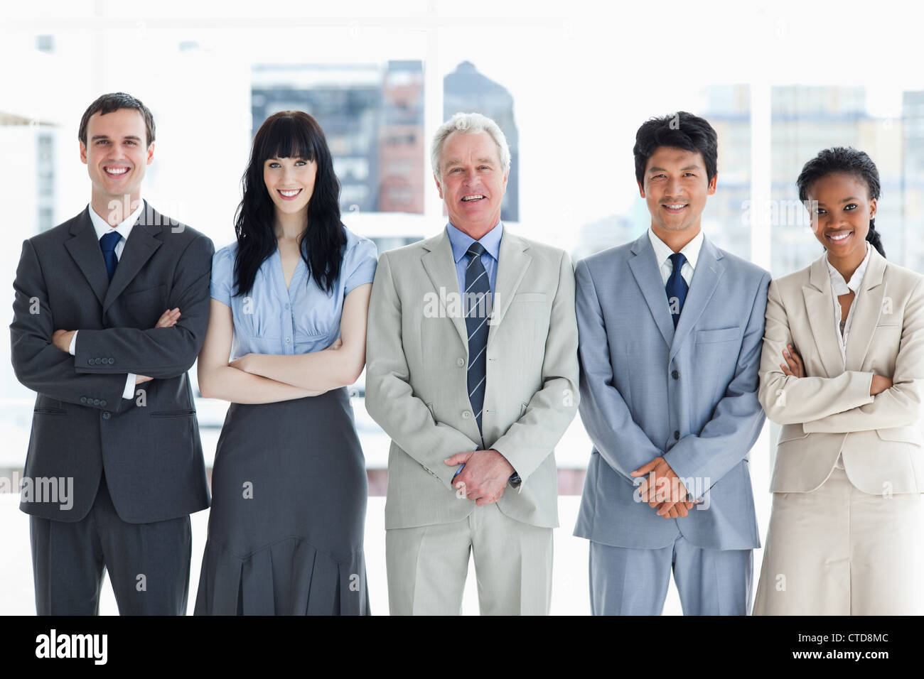 Five members of a business team standing upright while smiling Stock ...