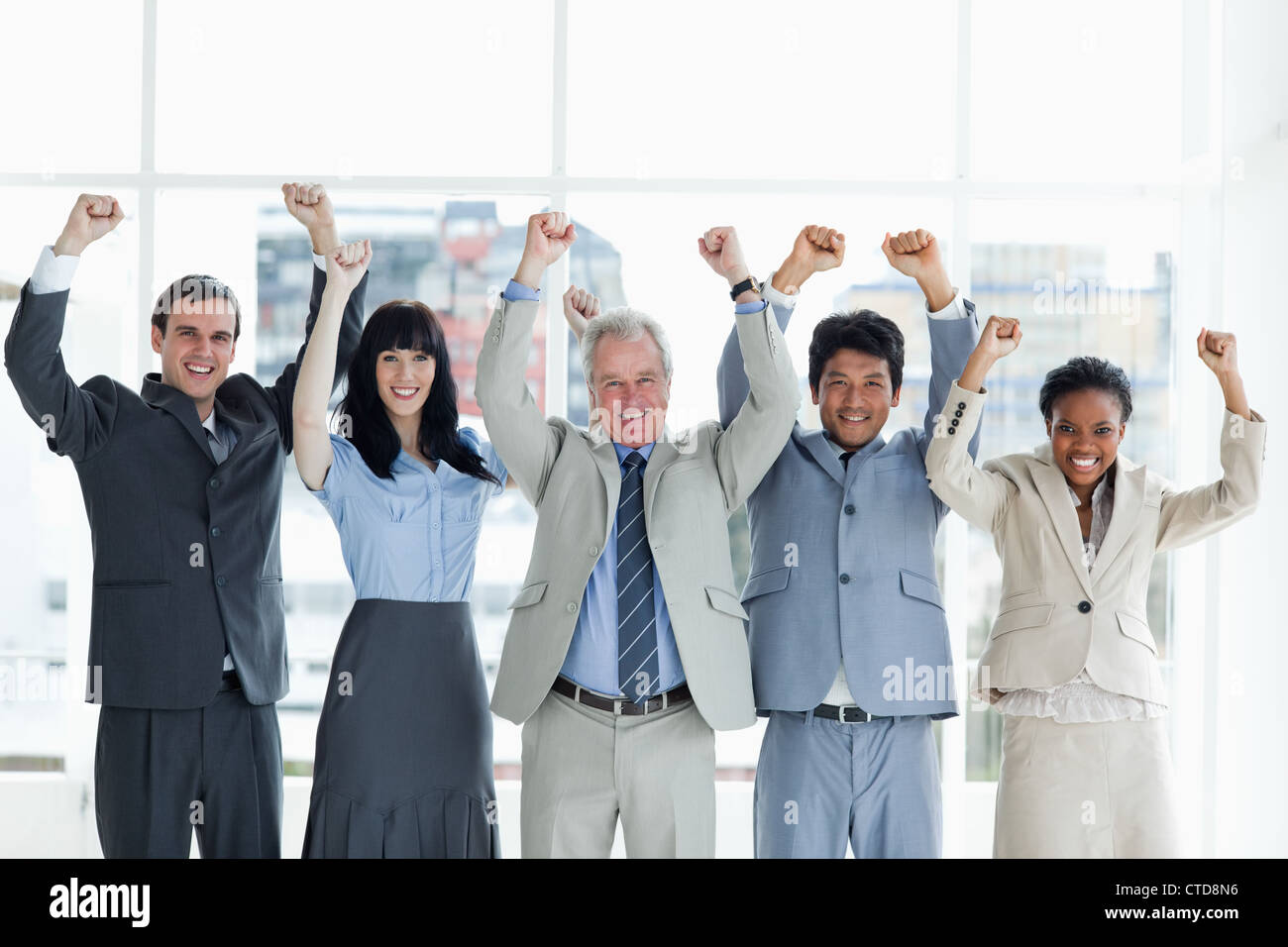 Five business people showing their approval with their arms raised ...