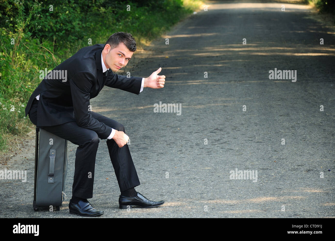 Business man thumb a ride on road Stock Photo - Alamy
