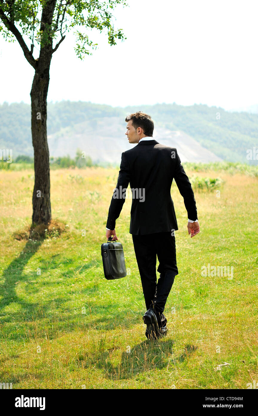 Business man walking in nature Stock Photo - Alamy