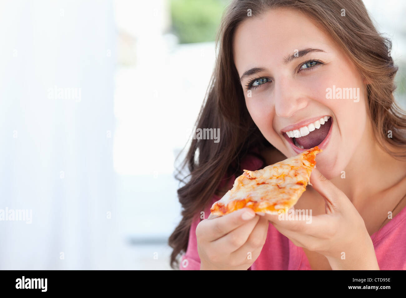 A woman with a pizza slice at her lips Stock Photo - Alamy