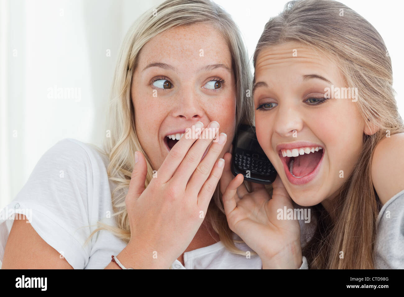 A smiling pair of sister making a call Stock Photo - Alamy