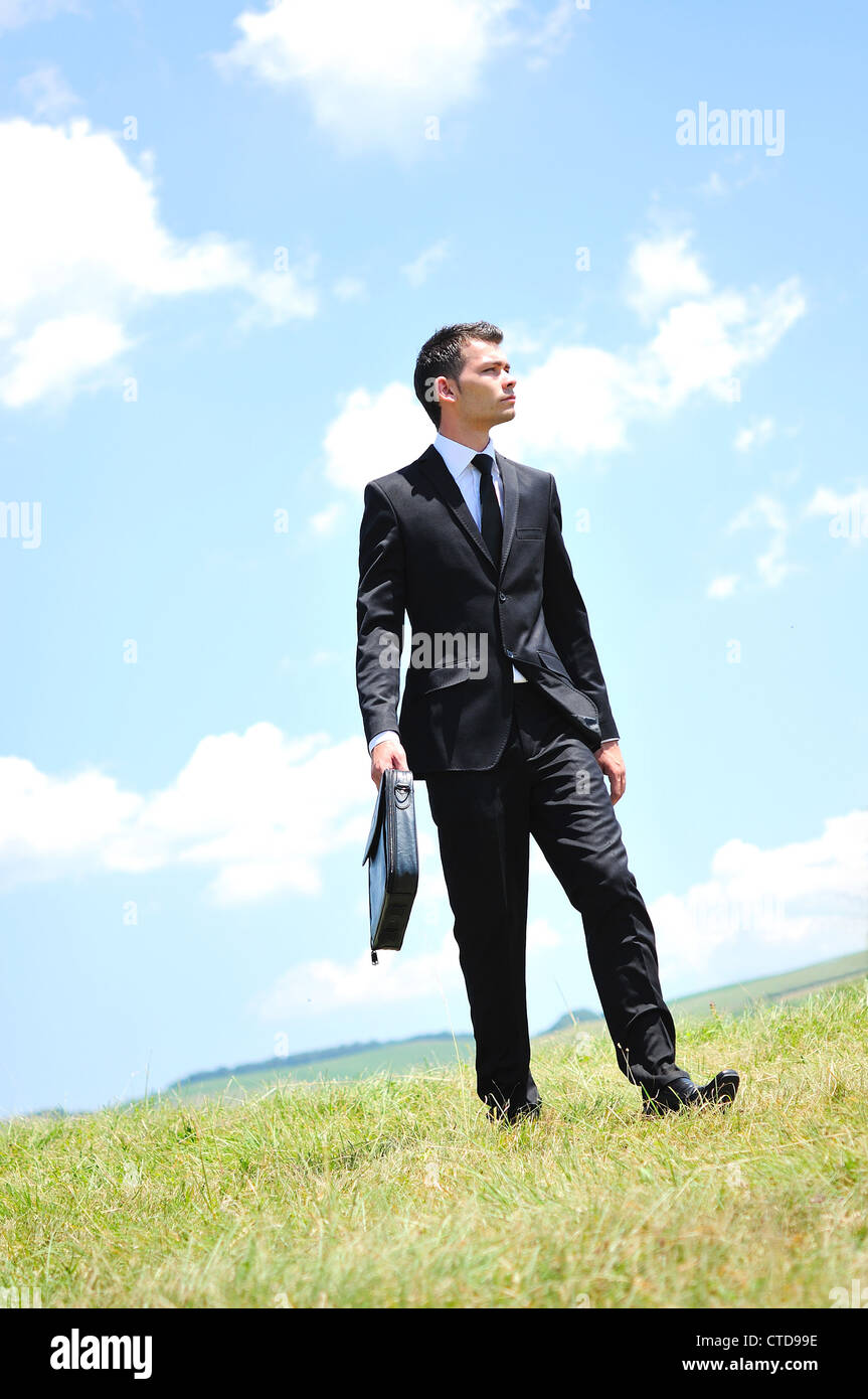 Business man walking in nature Stock Photo - Alamy