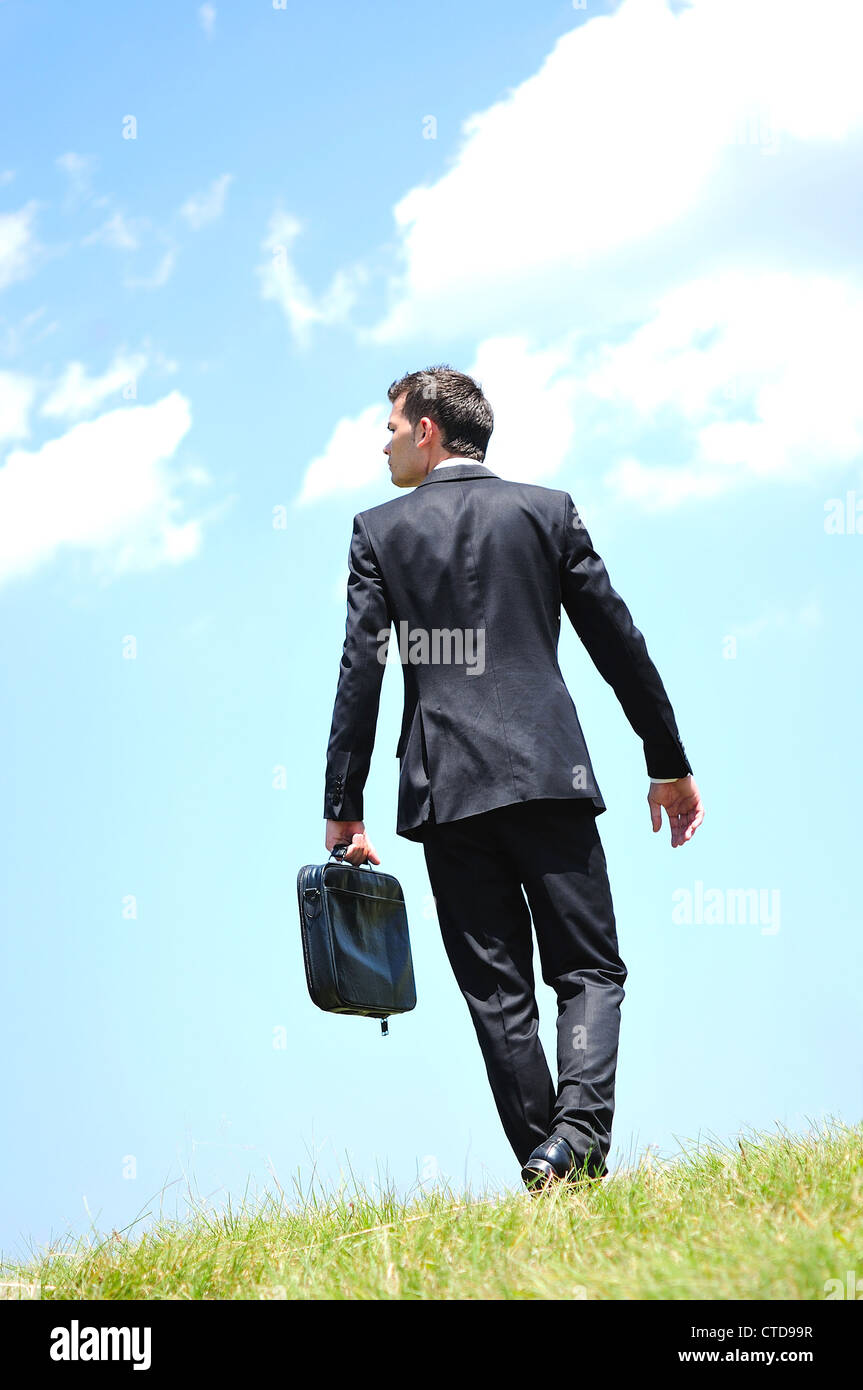 Business man walking in nature Stock Photo - Alamy