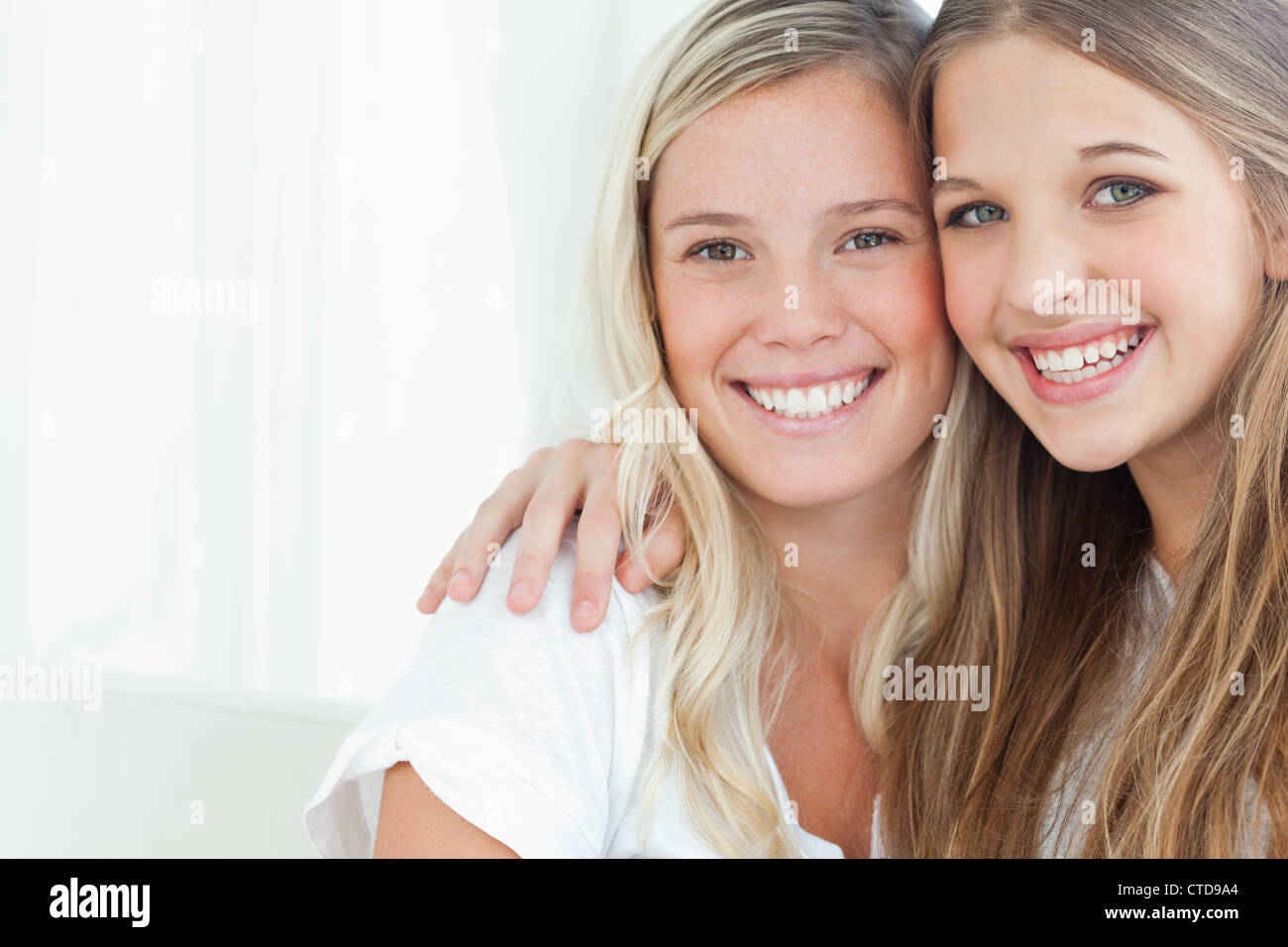 A smiling pair of sisters looking at the camera Stock Photo - Alamy